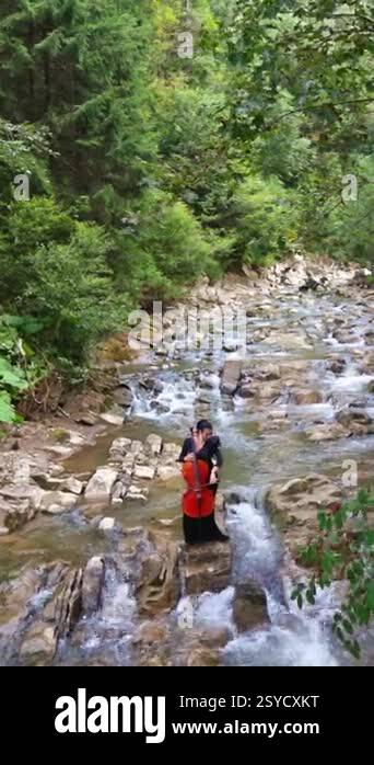 Cellist playing on instrument outdoors. Female musician performs on ...