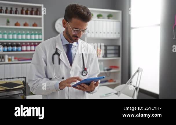 Doctor in a clinic using a tablet in an indoor hospital setting with ...