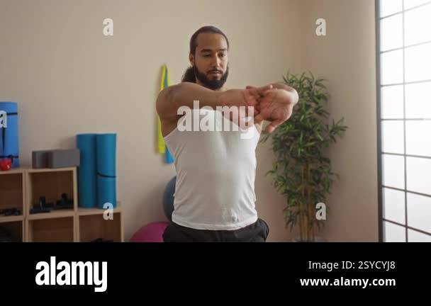 Man stretching in calm wellness room with yoga mats, plants, and ...