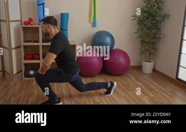 Young man exercising in an indoor gym setting with fitness equipment ...