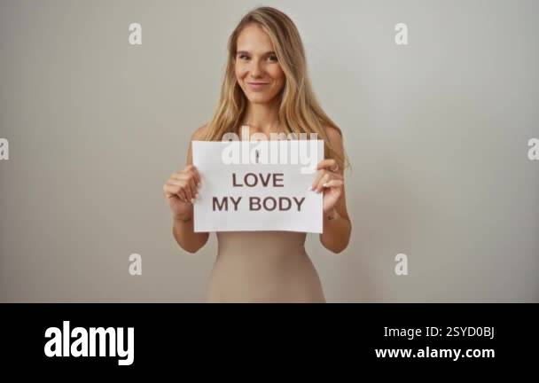 Woman holding sign with i love my body message in a bright room with ...