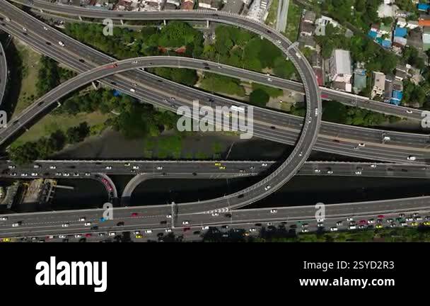 Top view of a busy highway loop crossing through dense urban areas with ...