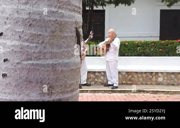 Two colombian men standing singing and playing an acoustic guitar in ...