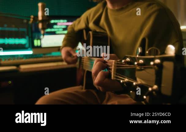 Side cropped shot of faceless musician playing guitar while recording ...