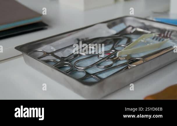 Metallic or steel surgical instruments in tray with sterile napkin ...