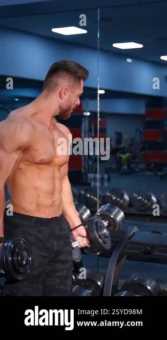 Strong Athletic Fit Man. Good looking young man lifting dumbbells and ...