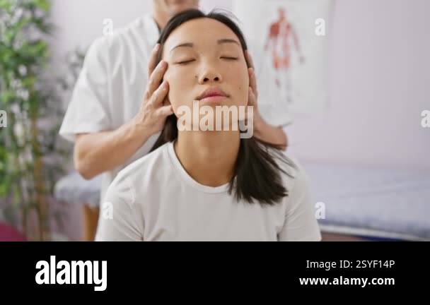 Therapist giving a neck massage to a relaxed woman in a clinic with ...