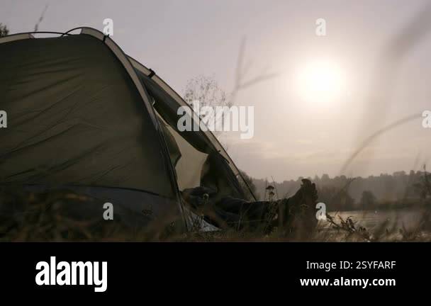 A peaceful morning scene unfolds inside a tent, illuminated by the warm ...