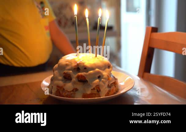 A delicious birthday cake with four candles. The child blows out the ...