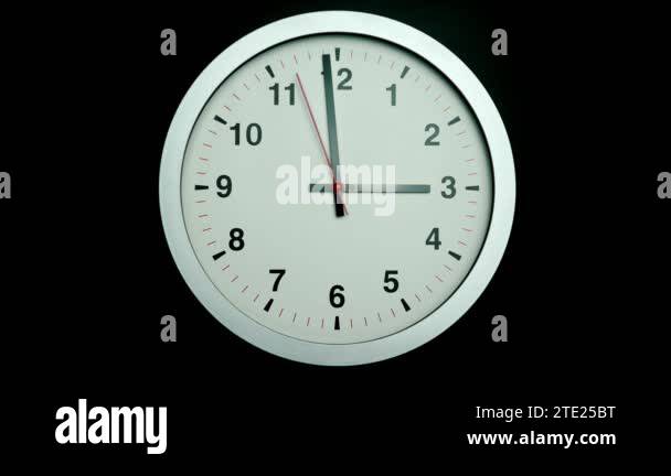 White wall clock tells the time of three o'clock. Slow rotation of the ...