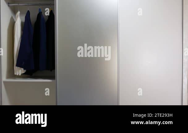 Wardrobe with clothes. The system of sliding doors in the wardrobe, the system of opening and ...
