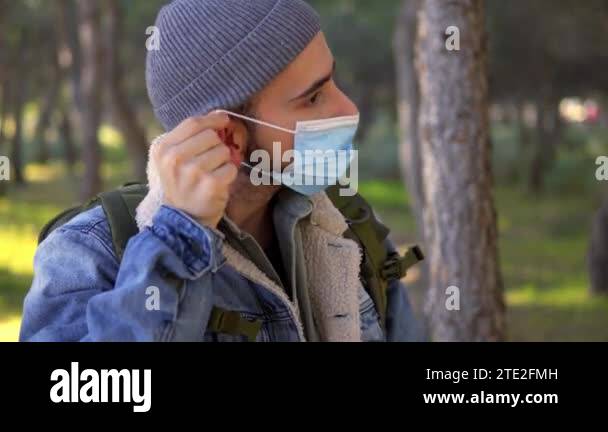 Young man removing his mask to start a route through the wood. The mask ...