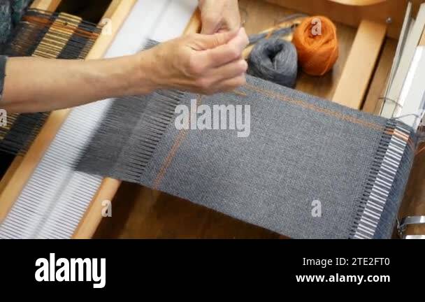 Artisan finishing the weaving project to stop it from unraveling ...