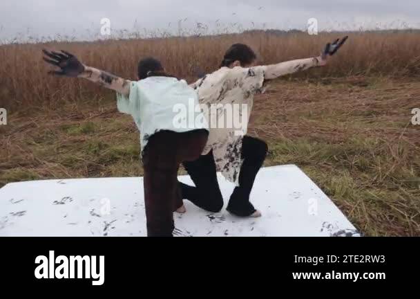 Two young girls perform an alternative dance in a wheat field with ...