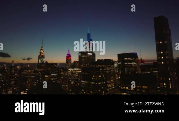 Descending footage of high rise buildings with lighted windows. Iconic ...