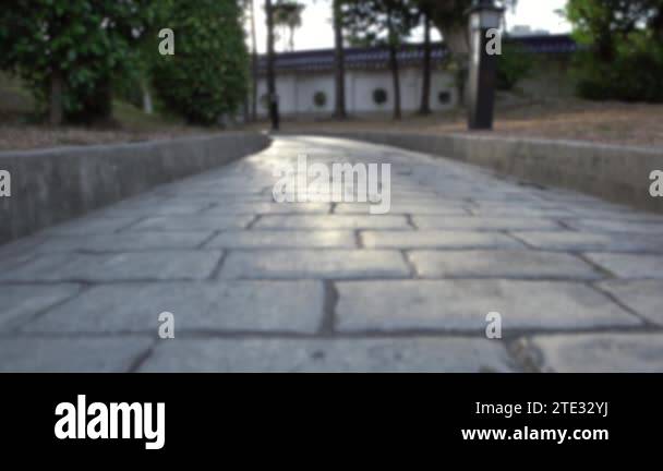 Defocused shot of paving stone road. Old pavement of square cobblestone ...