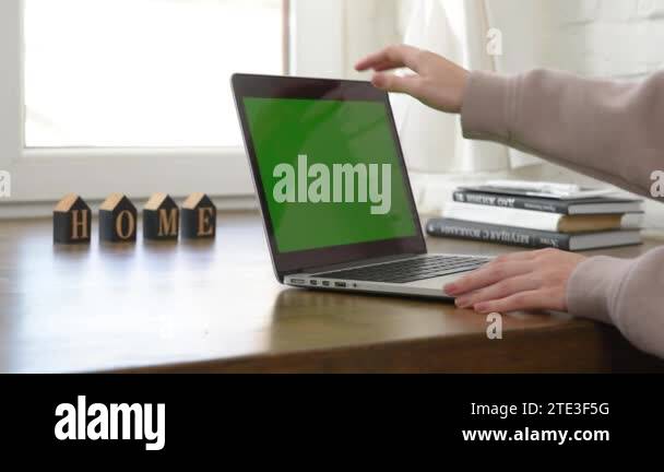 Close-up of women's hands covering laptop with green screen against ...
