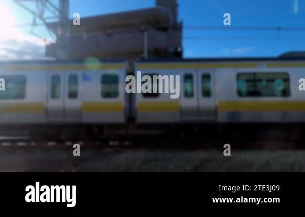 Defocused shot of train travels over railroad through the Tokyo city ...