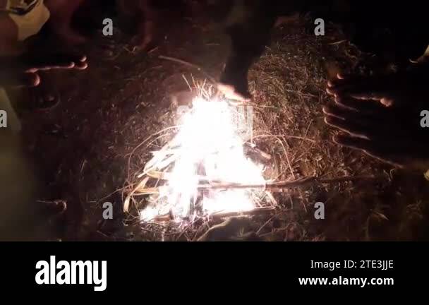 Wooden fire. People of village heating fire in cold weather. Rural area ...