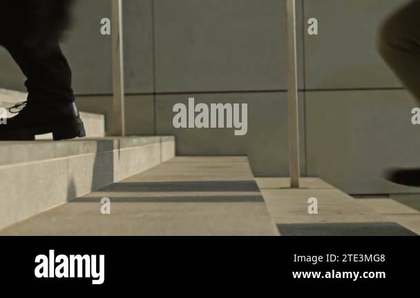 The feet of different people rush up the stairs of an underground ...
