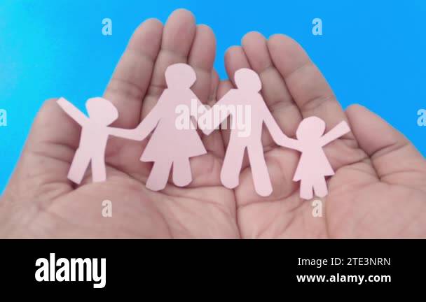 Happy paper family on a man hand with palm facing upwards against blue ...