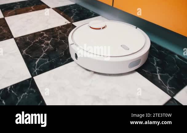 The Robot Vacuum Cleaner Cleans in the Modern House on the Tiles Floor ...