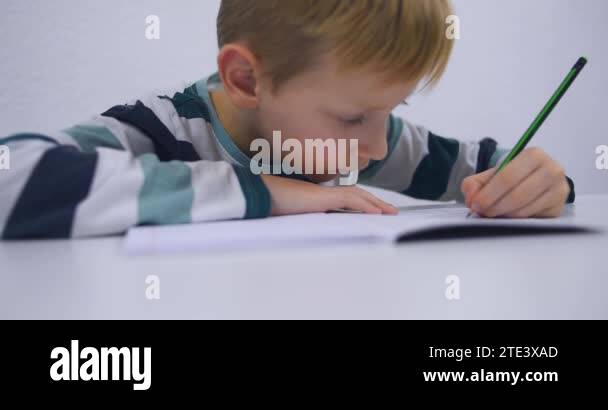 School boy practicing writing the alphabet at home. Boy child kid ...
