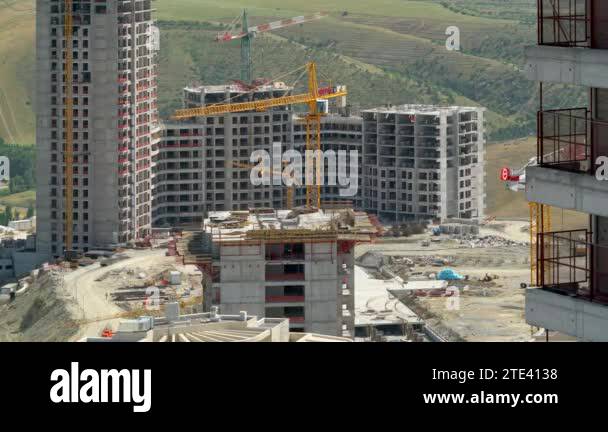 Cinematic 8K 7680x4320.Cranes and construction workers working at a ...
