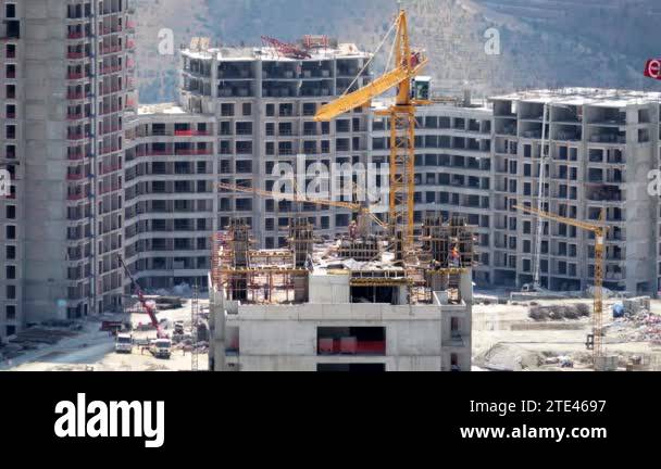 Cinematic 8K 7680x4320.Cranes and construction workers working at a ...