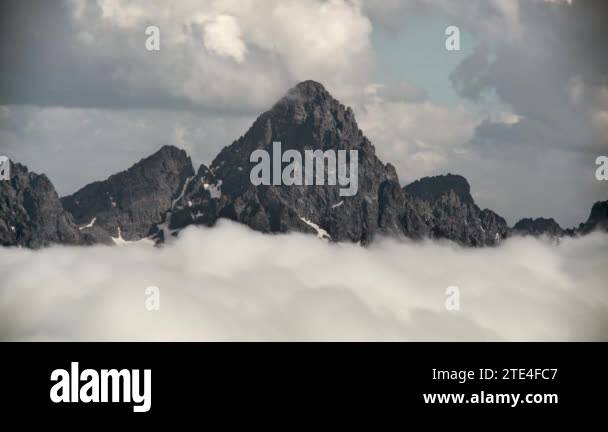 8K 7680x4320 4320p.Sharp rocky mountain peak above the clouds.Dangerous high altitude summit ...