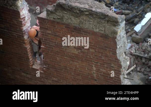 Demolition of old abandoned house, workman in orange helmet destroy ...