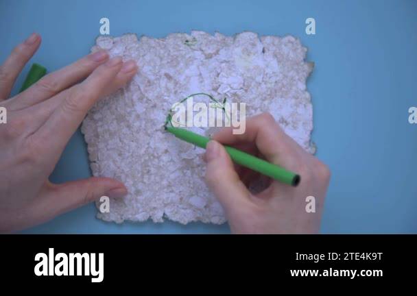 Womens hands draw a sign of reuse with a green felt-tip pen. Drawing on ...