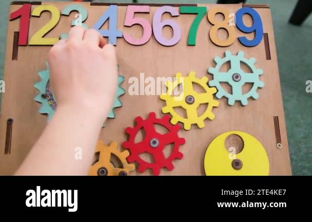 Busy Board for children, wooden board with numbers, gears are spinning ...