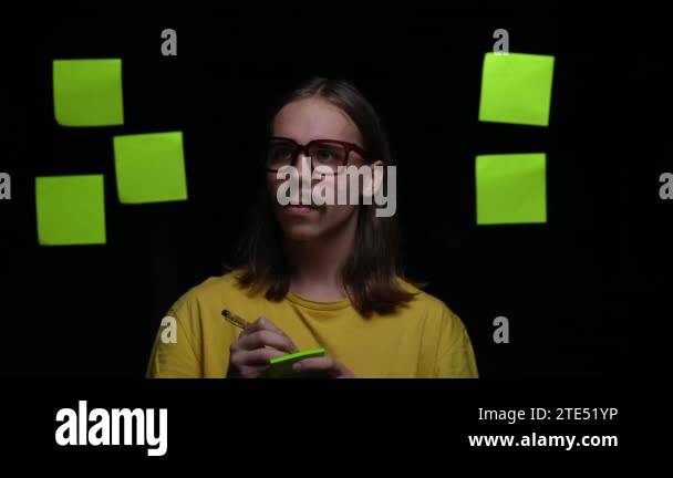 Portrait of young guy writing down his thoughts with pen on sticky ...