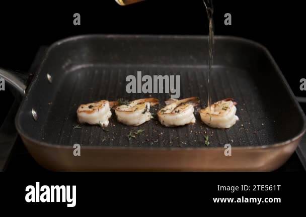 juicy shrimp are fried in a frying pan. pour alcohol into the pan and ...