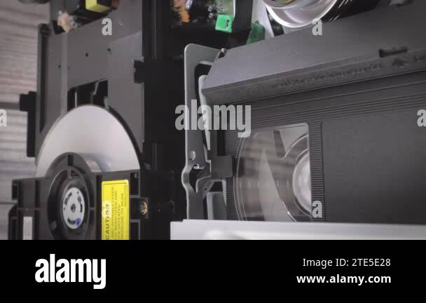 Closeup shot of a vhs cassette and a dvd being removed from a player ...