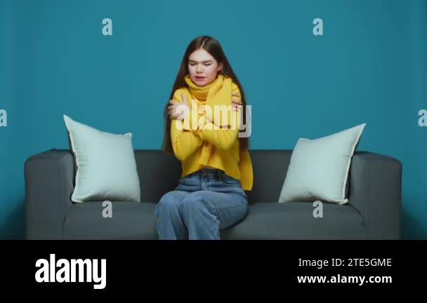Young girl freezing sitting on couch in cold room suffer from chill ...