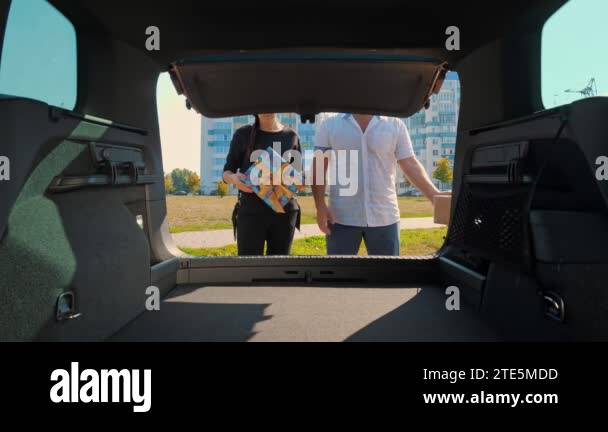 delivery. donation, charity. gift boxes in car. man and woman load ...