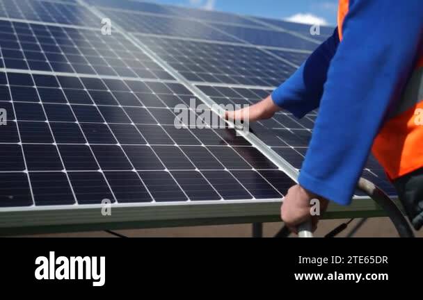 Solar power plant worker checks joints and defects on solar panels with ...