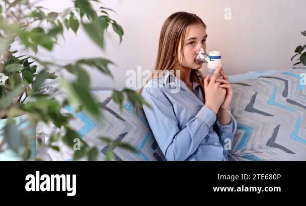 Teenage girl makes inhalation with a nebulizer equipment. Sick child ...