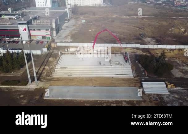 Aerial of concrete boom pump crane arm truck with outriggers pouring ...