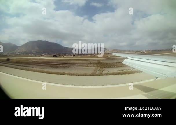 Passenger airplane landing on runway, view through window, wing and ...