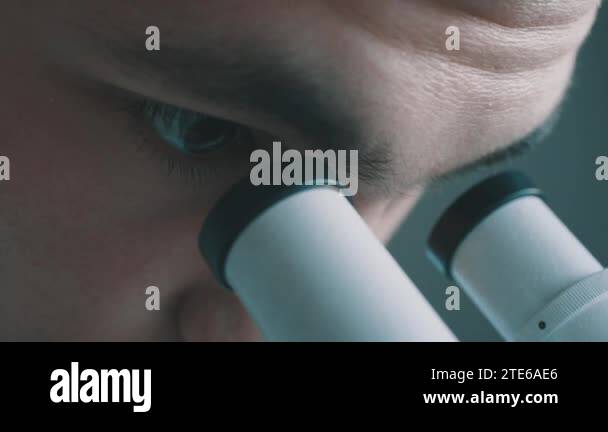 Young doctor looking through the microscope Stock Video Footage - Alamy