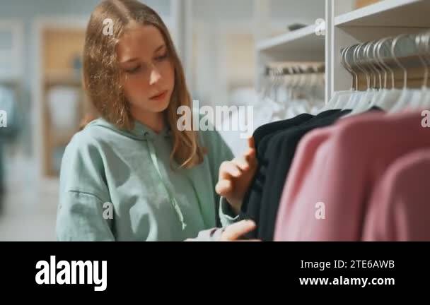Teenage girl choosing clothes in mall Stock Video Footage - Alamy