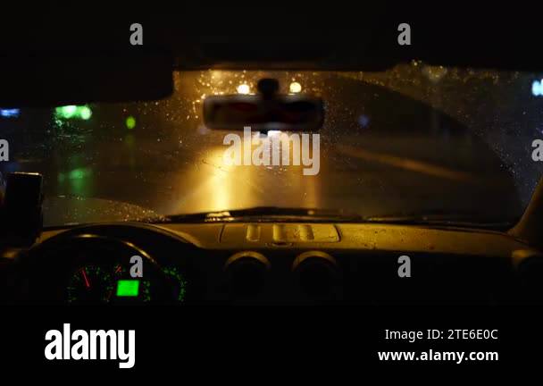 Man driving through a heavy rain storm in a dark rainy city. Night ...