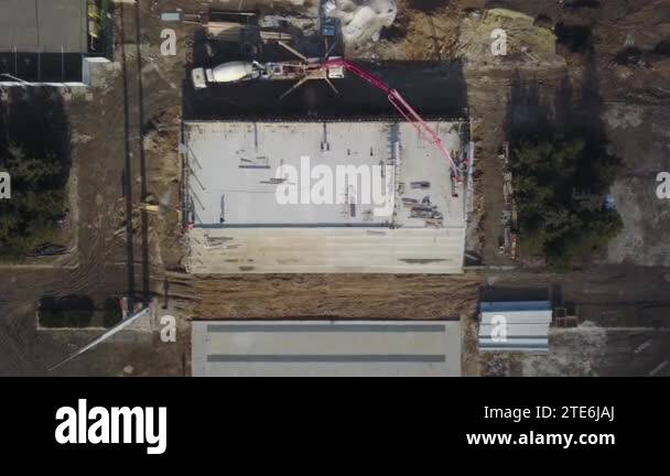 Aerial of concrete boom pump crane arm truck with outriggers pouring ...