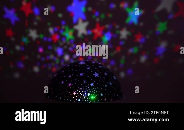 kids projector reflects moving colorful stars on the wall creating ...