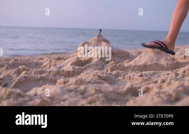 A boy tramples a sand castle on the seashore with his feet Stock Video ...