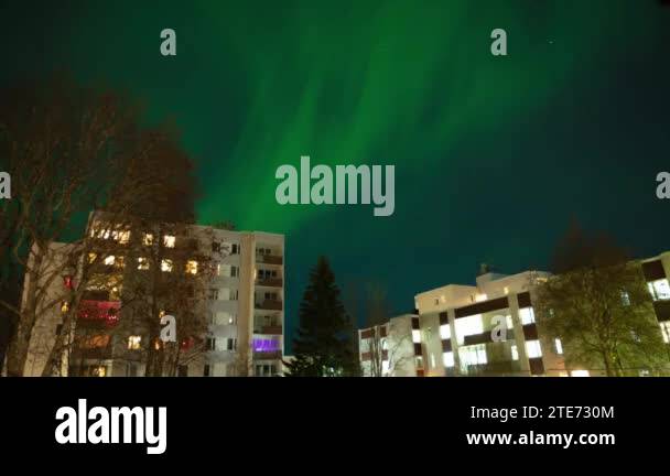 Green and pink aurora northern light dancing under a starry sky above ...