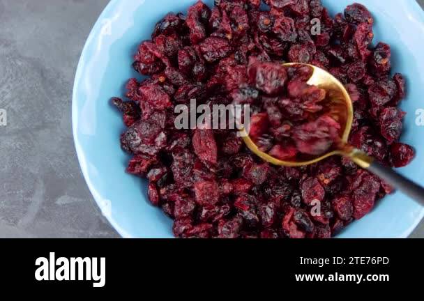 Dried cranberries blue bowl in hand top view. Healthy tasty dry red ...